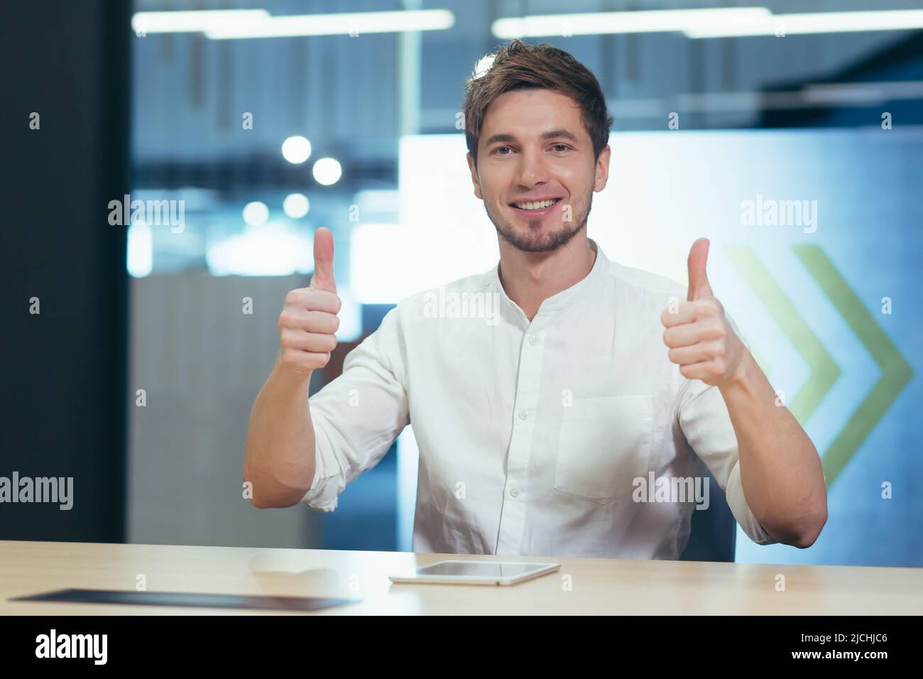 Man in modern office working, talking on video call looking at camera ...