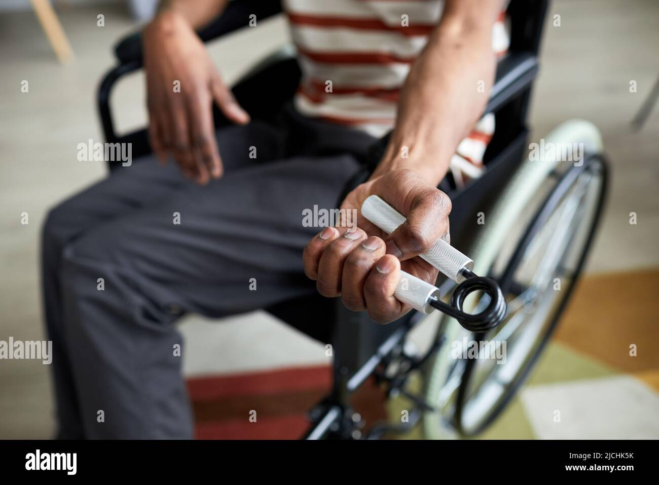 Closeup of man in wheelchair exercising hand and arm muscles by using ...