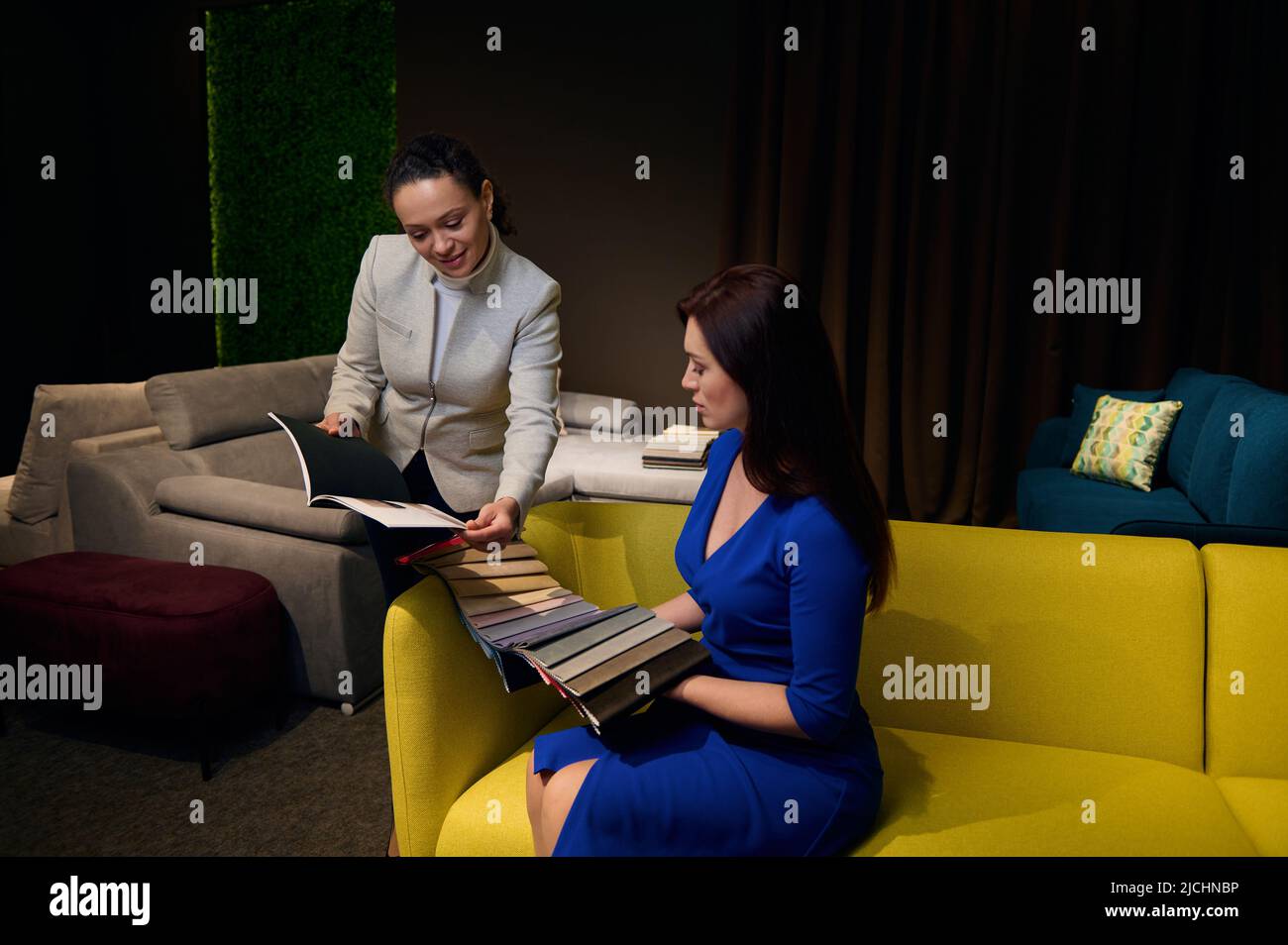 Hispanic woman, pleasant retail manager at a furniture store presenting ...