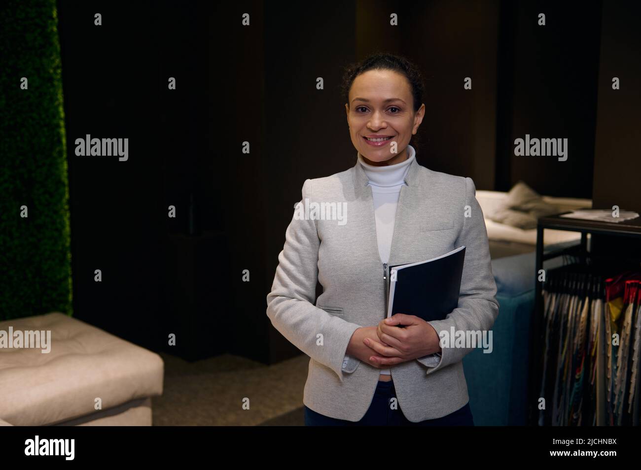 African pretty woman, sales manager, interior designer stands near ...