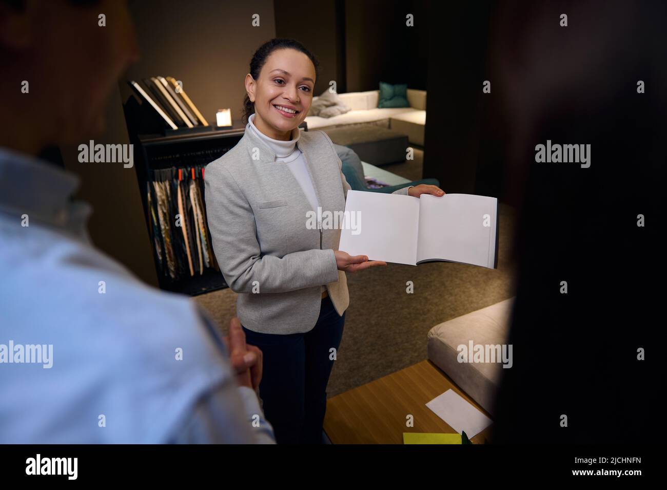 Multiethnic pretty woman sales assistant smiles to customers while ...