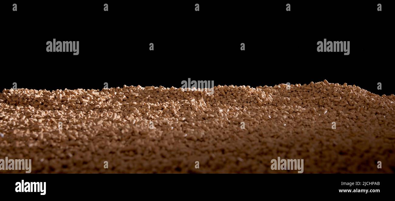Heap of cylinder shaped solid fuel pellets scattered on surface against ...
