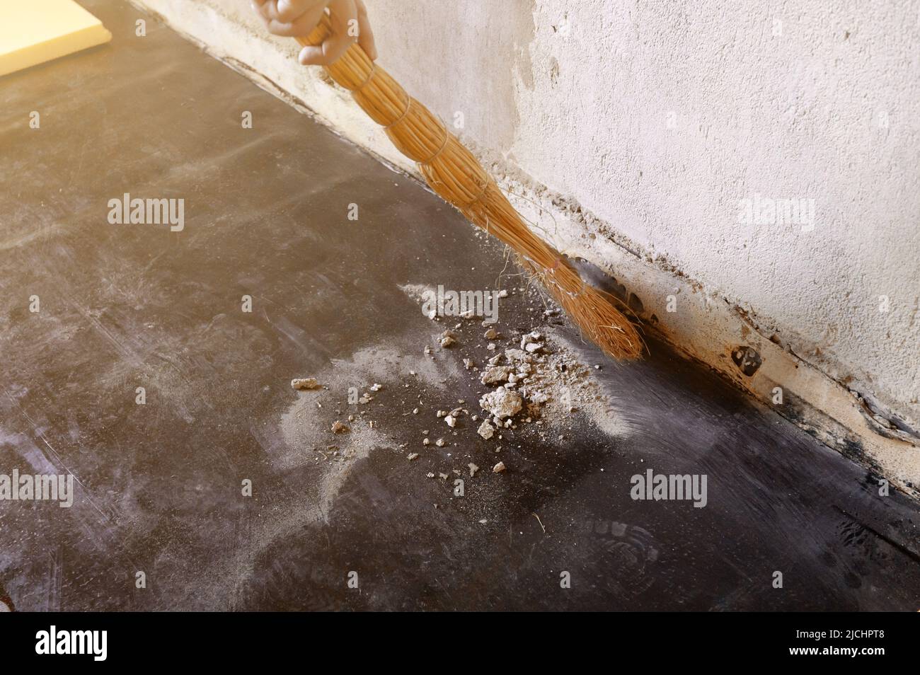 Worker sweeps construction debris with a broom Stock Photo - Alamy