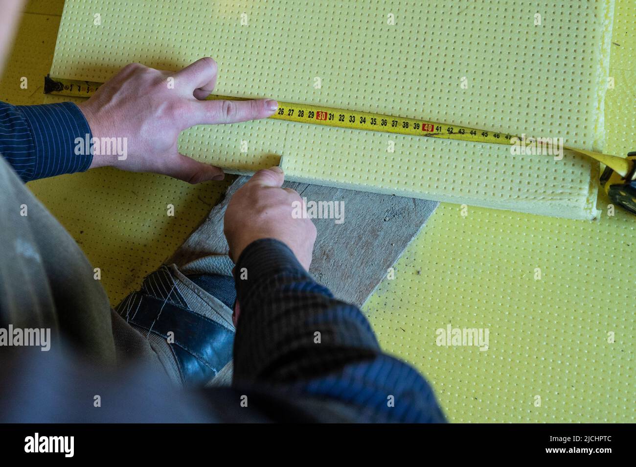 The master measures the length of expanded polystyrene on the floor ...