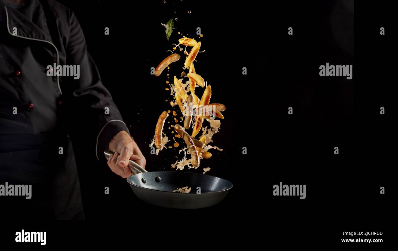 Anonymous chef in uniform tossing appetizing fried Schupfnudeln with ...