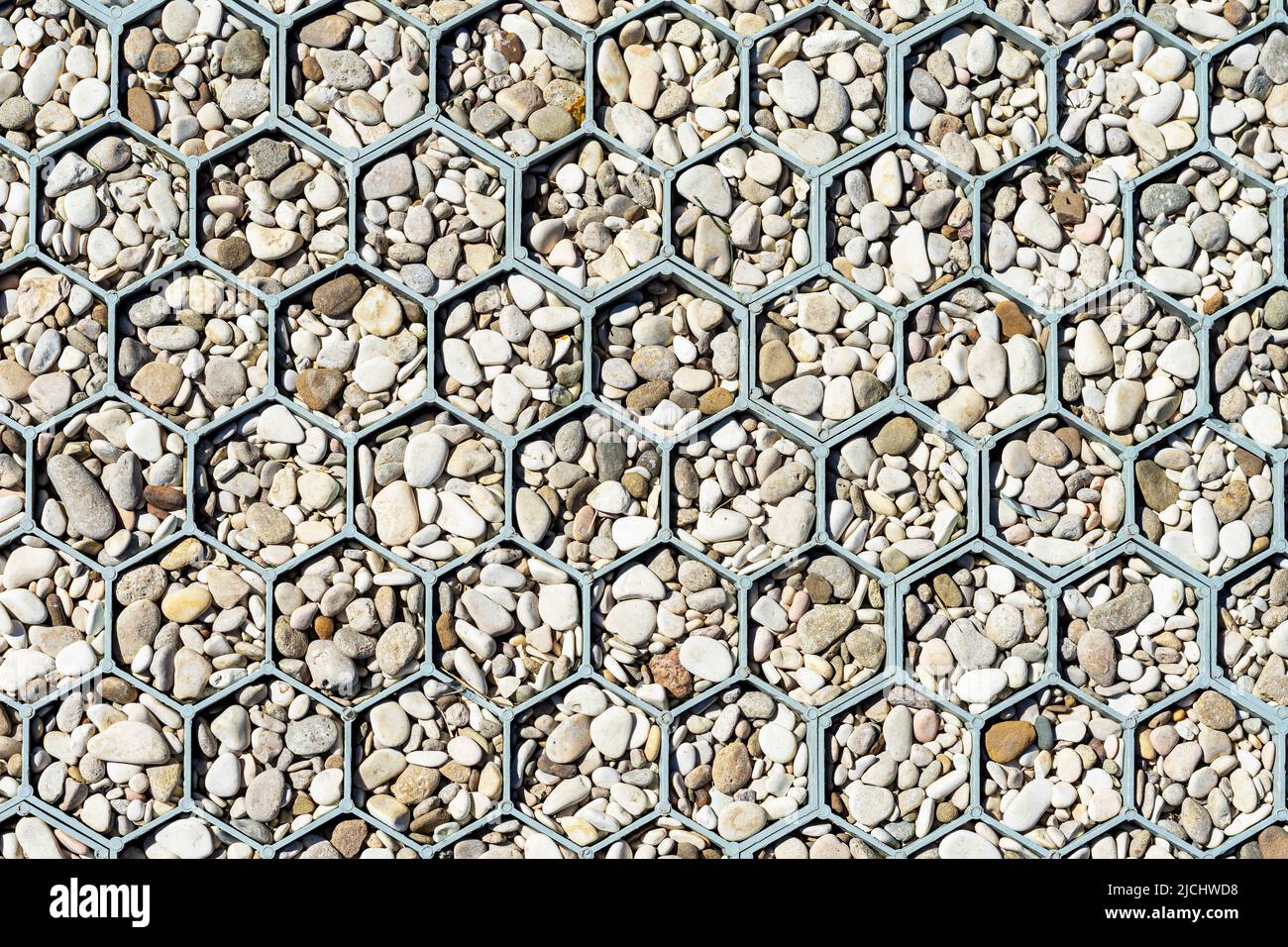 Natural background, texture of small pebbles surrounded by honeycomb ...
