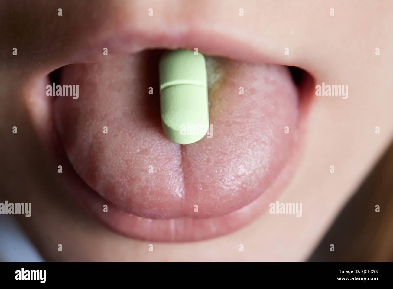 Close up of face of young woman taking drug. The drug addict is ...