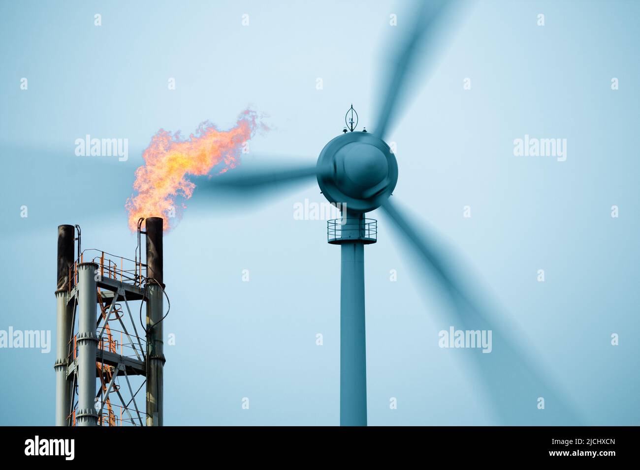 Wind turbine and gas processing plant chimney. Global warming, climate ...