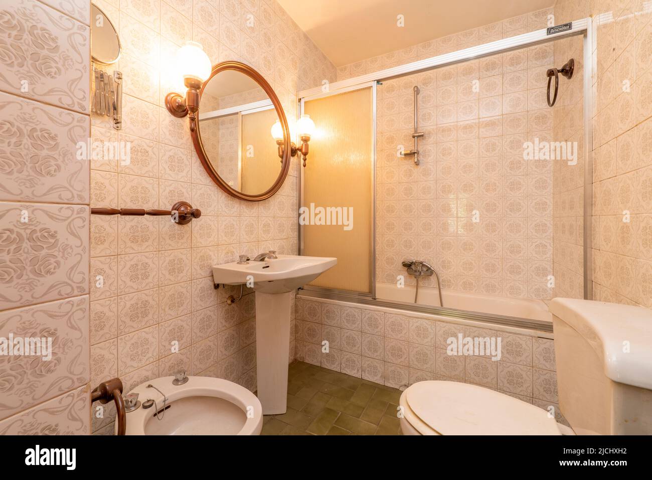 Vintage bathroom with kitsch tiles, cream-colored toilets and aluminum ...