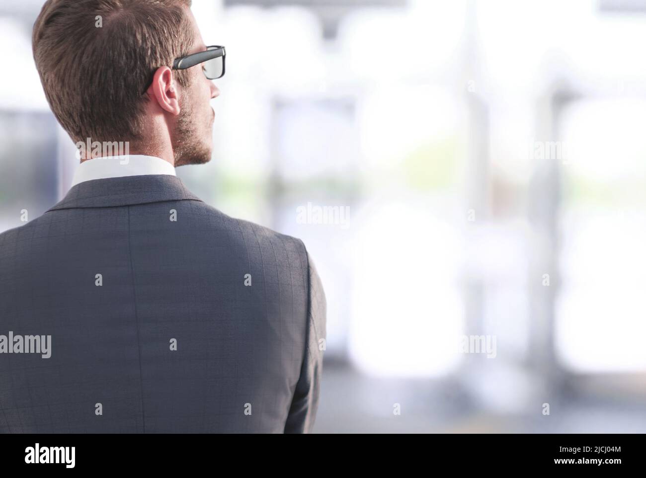 rear view.businessman standing near the office window Stock Photo - Alamy