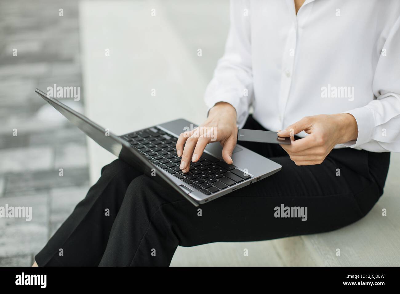Cropped view of hands holding laptop and bank credit card. Online ...