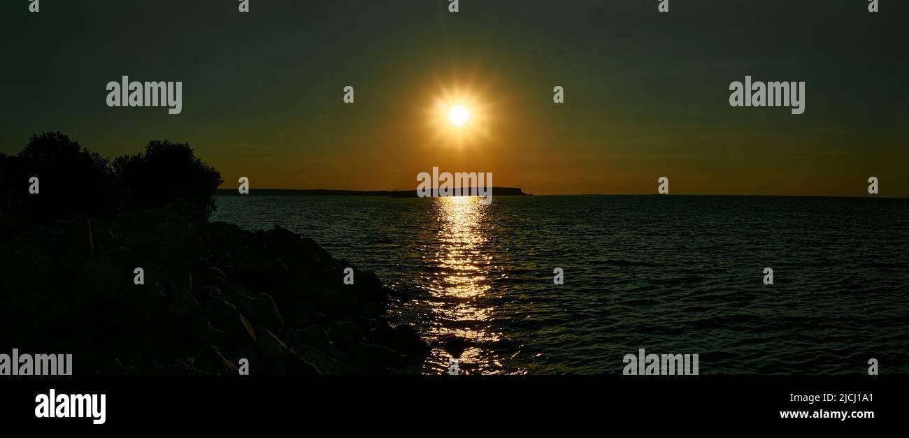Sunset over the lake, sunny path at sunset, panorama Stock Photo - Alamy