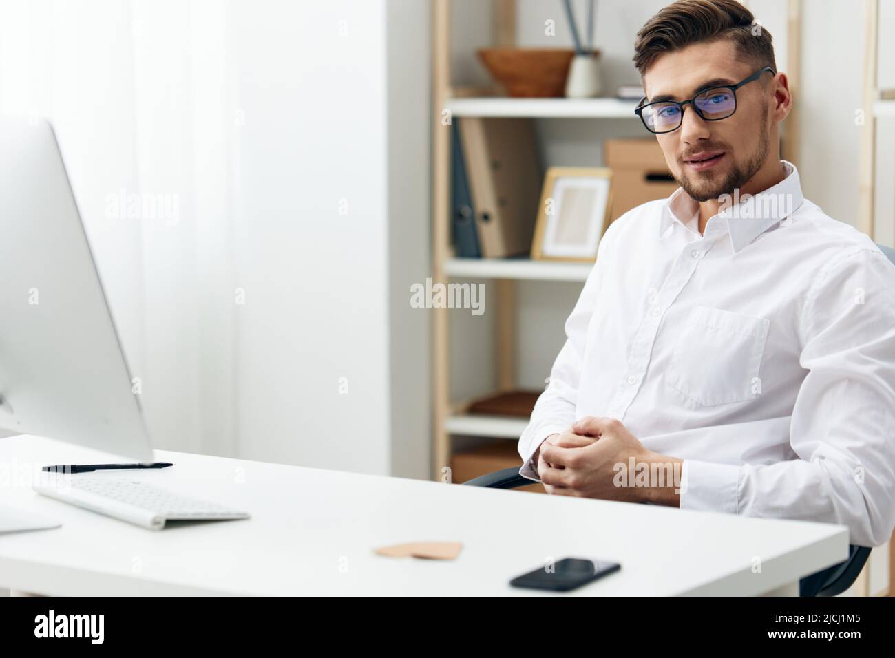 manager in a white shirt sits at a computer work office Stock Photo - Alamy