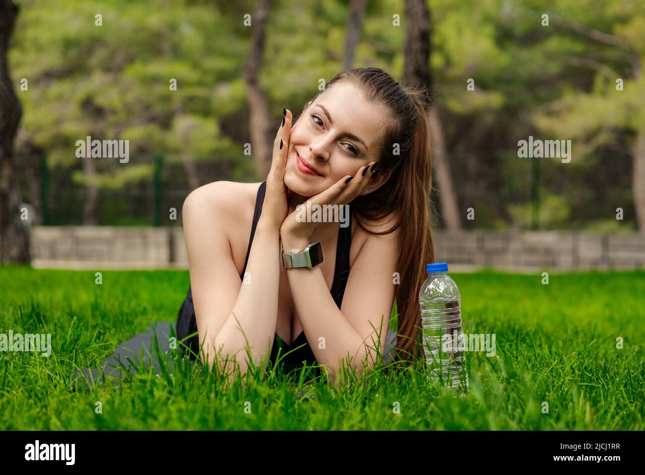 Happy sportive woman wearing sports bra standing on city park, outdoors ...