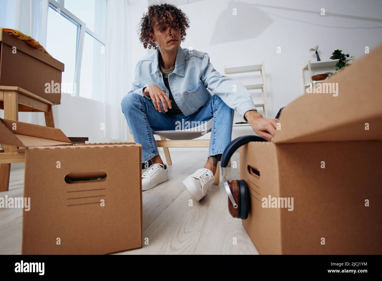 handsome guy cardboard boxes in the room unpacking headphones sorting ...