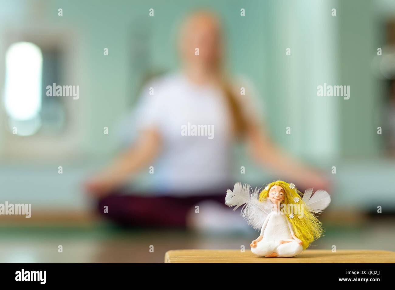 A doll in the form of an angel on blur background with healthy female ...