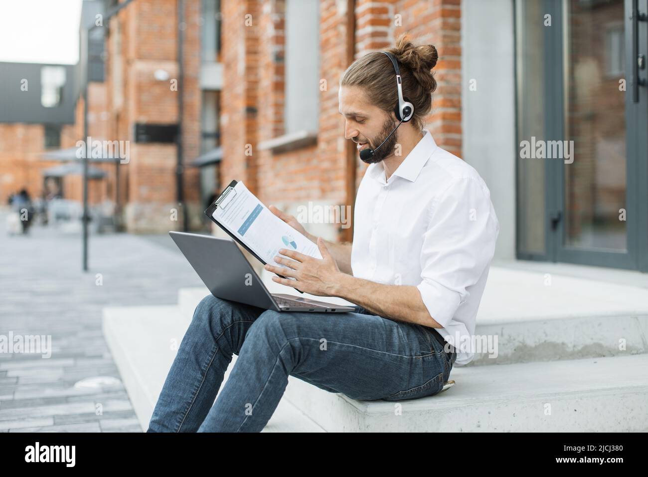 Focused attractive manager in headset leading working meeting through ...