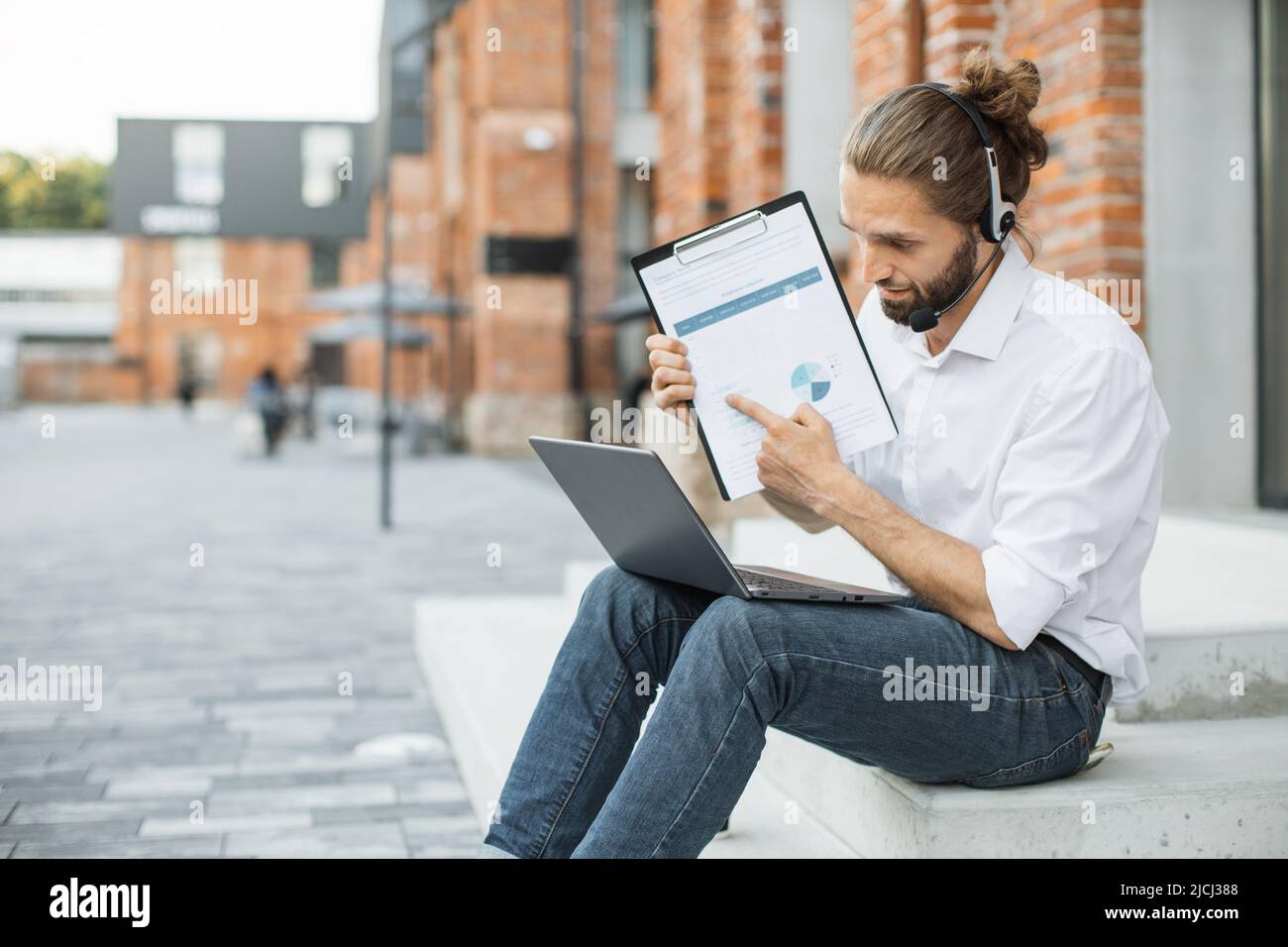 Focused attractive manager in headset leading working meeting through ...