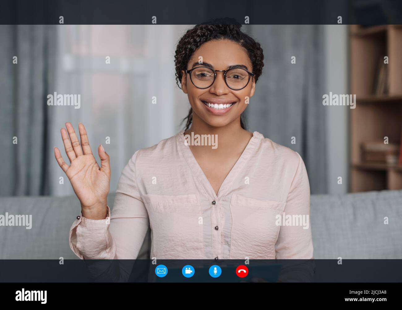 Happy african american young lady doctor in glasses waving hand at ...