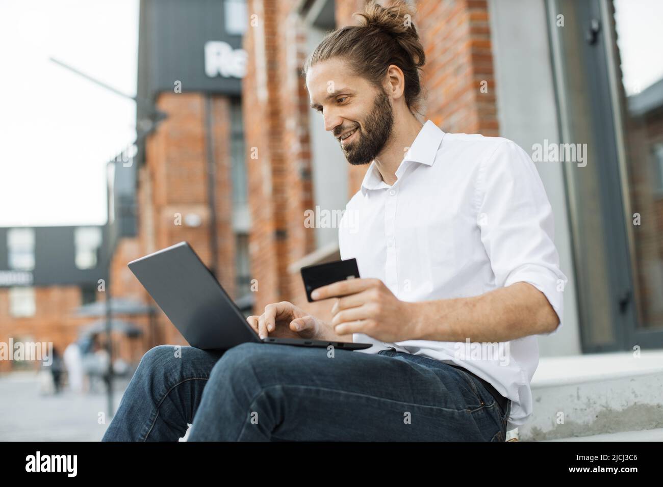 Handsome attractive man in white shirt using laptop and credit bank ...