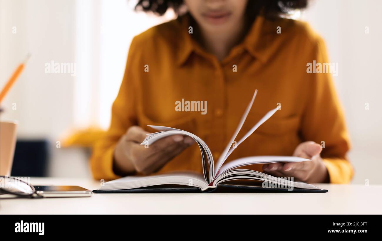 Education and free time. Young black woman reading book or writing ...