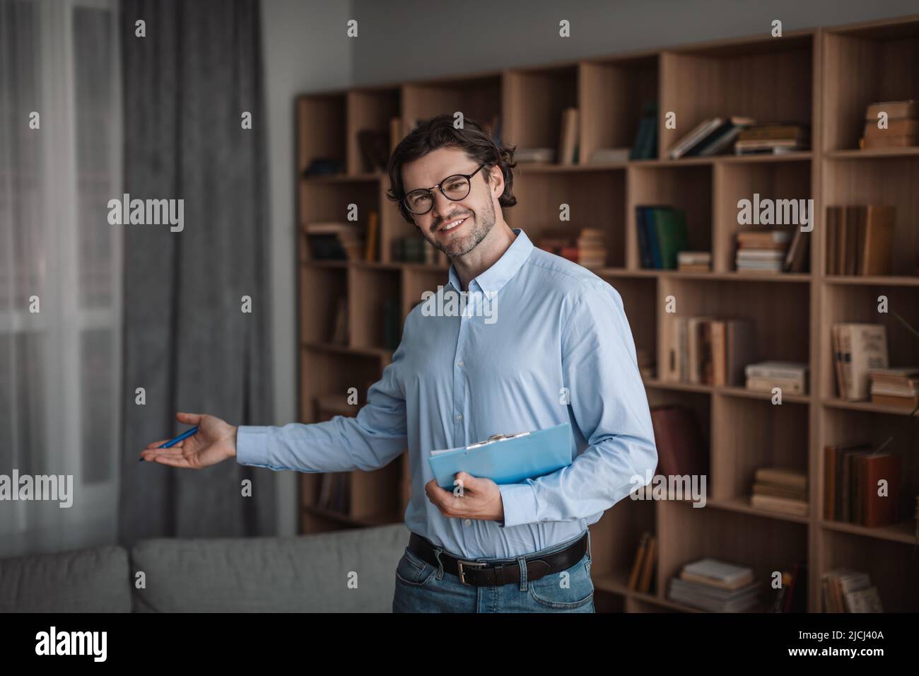 Happy european handsome millennial male psychologist in glasses invites ...