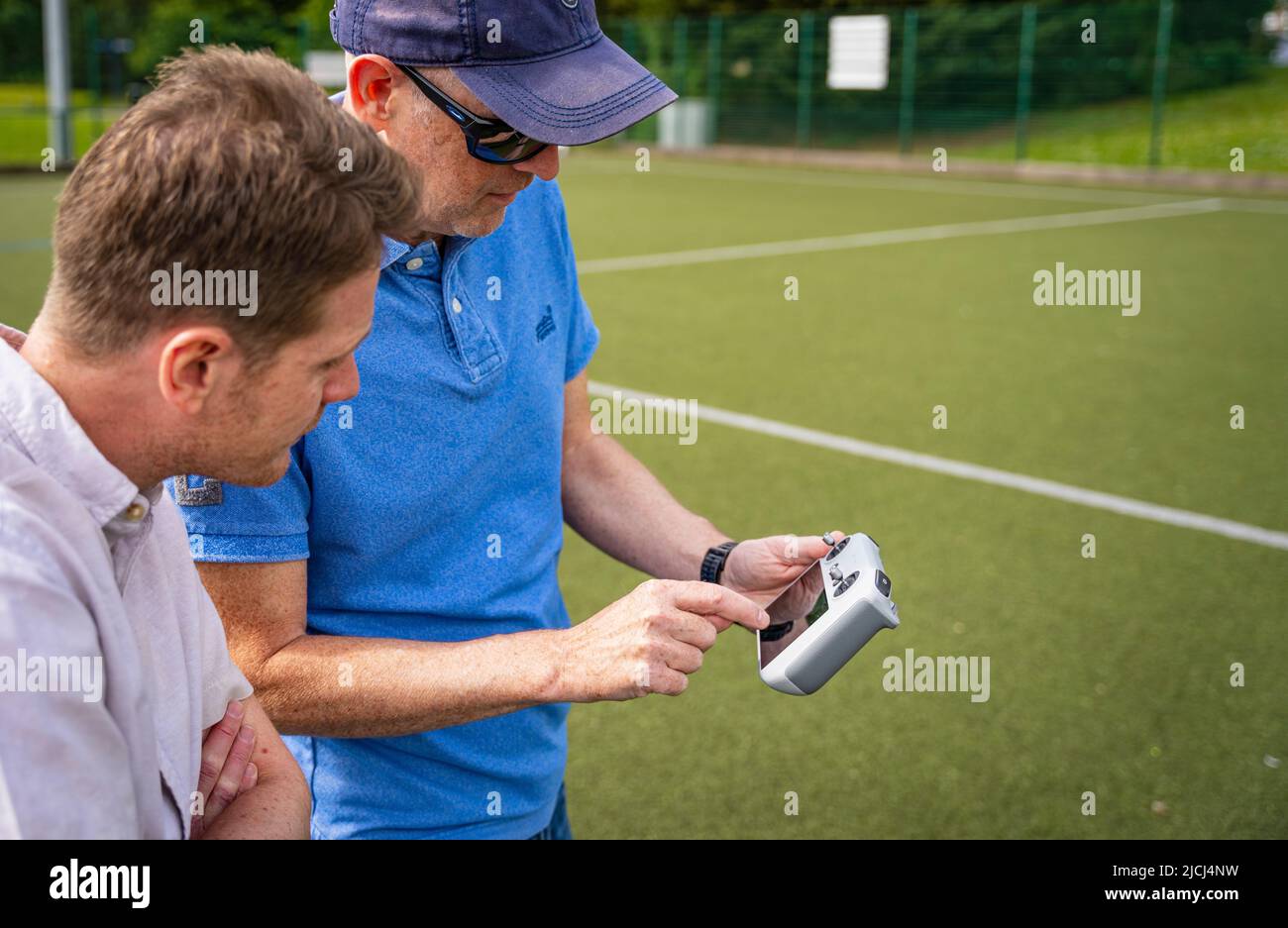 Crew / pilot operating a DJI Mini 3 Pro drone (UAV) using remote ...
