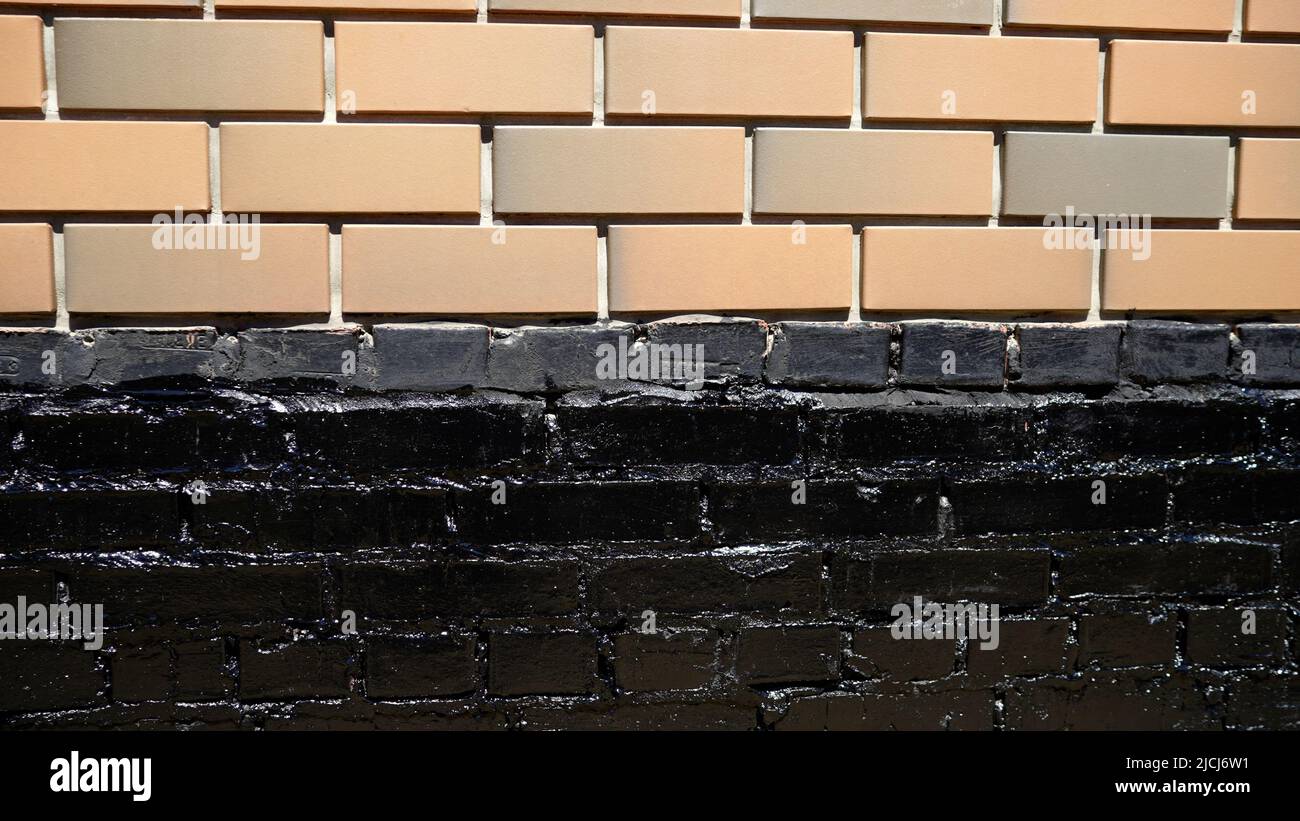 Black bituminous mortar outside the house. The bottom of the house ...