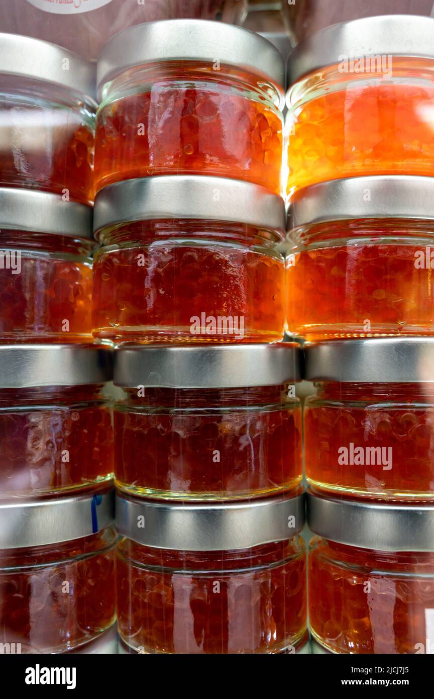 Small glass cans with real fish salmon and trout red, orange and yellow ...