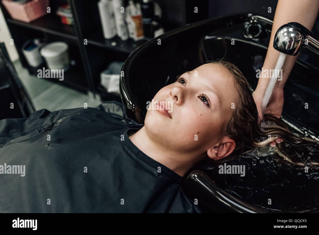 in an elite hairdresser's beautiful young woman washes her head in a ...