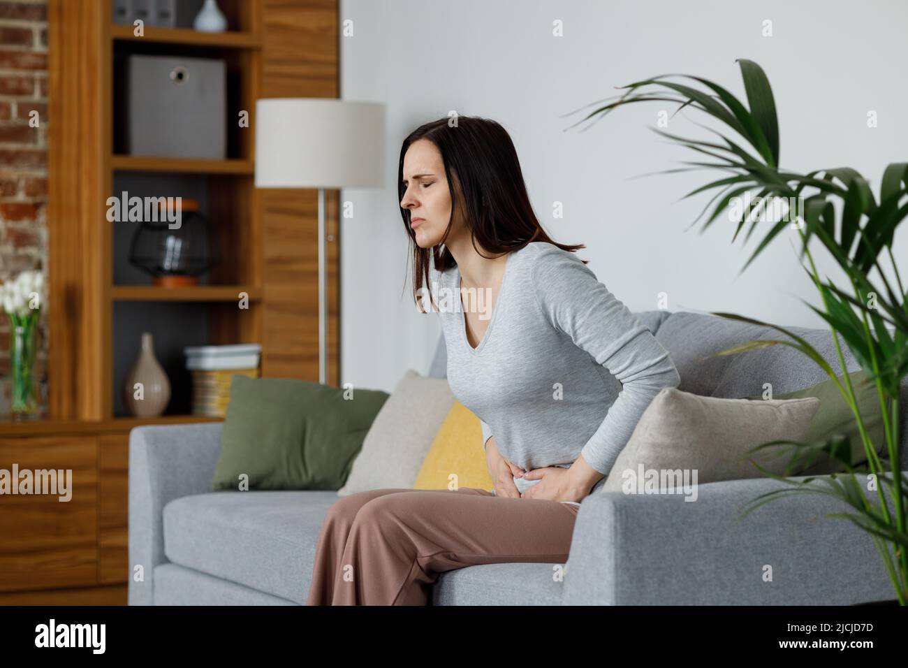 Sick young woman suffering from menstrual pain. Woman with hands ...