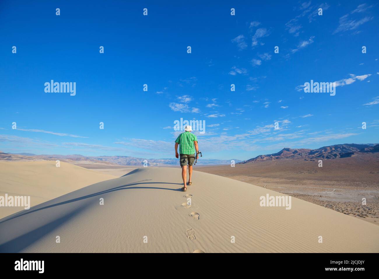 Hiker among sand dunes in the desert Stock Photo - Alamy