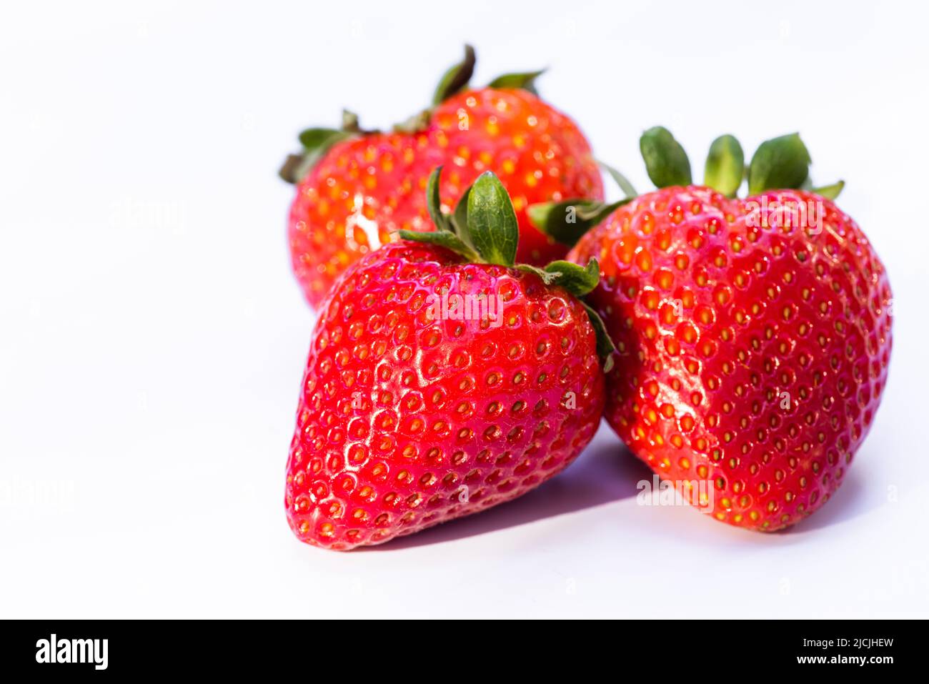 Three strawberries isolated on a white background Stock Photo - Alamy