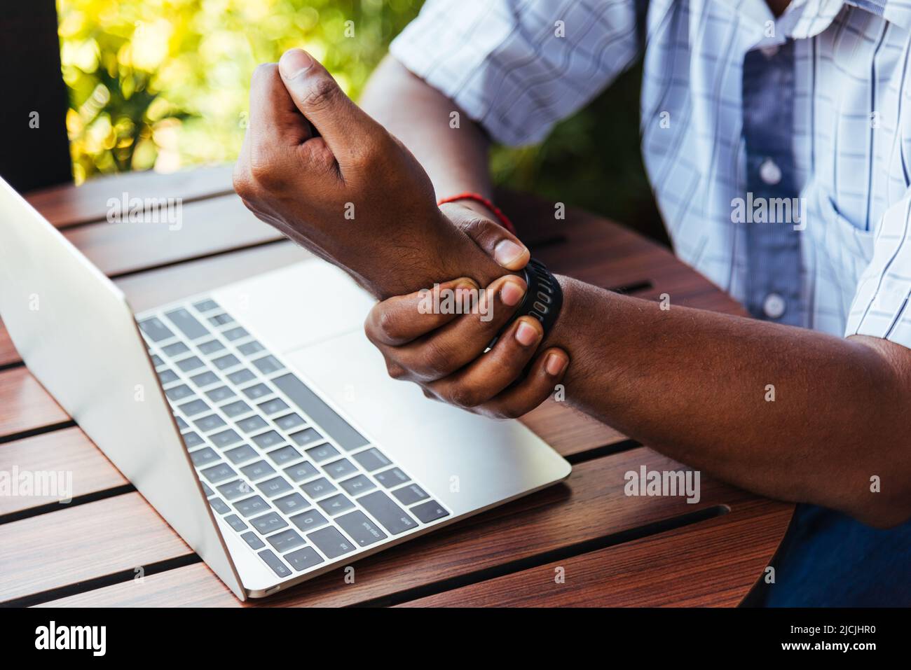 Closeup hands the Asian black man holding his wrist pain from using ...