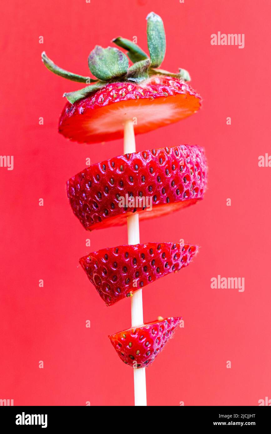 Close up of a sliced strawberry floating over a red background Stock ...