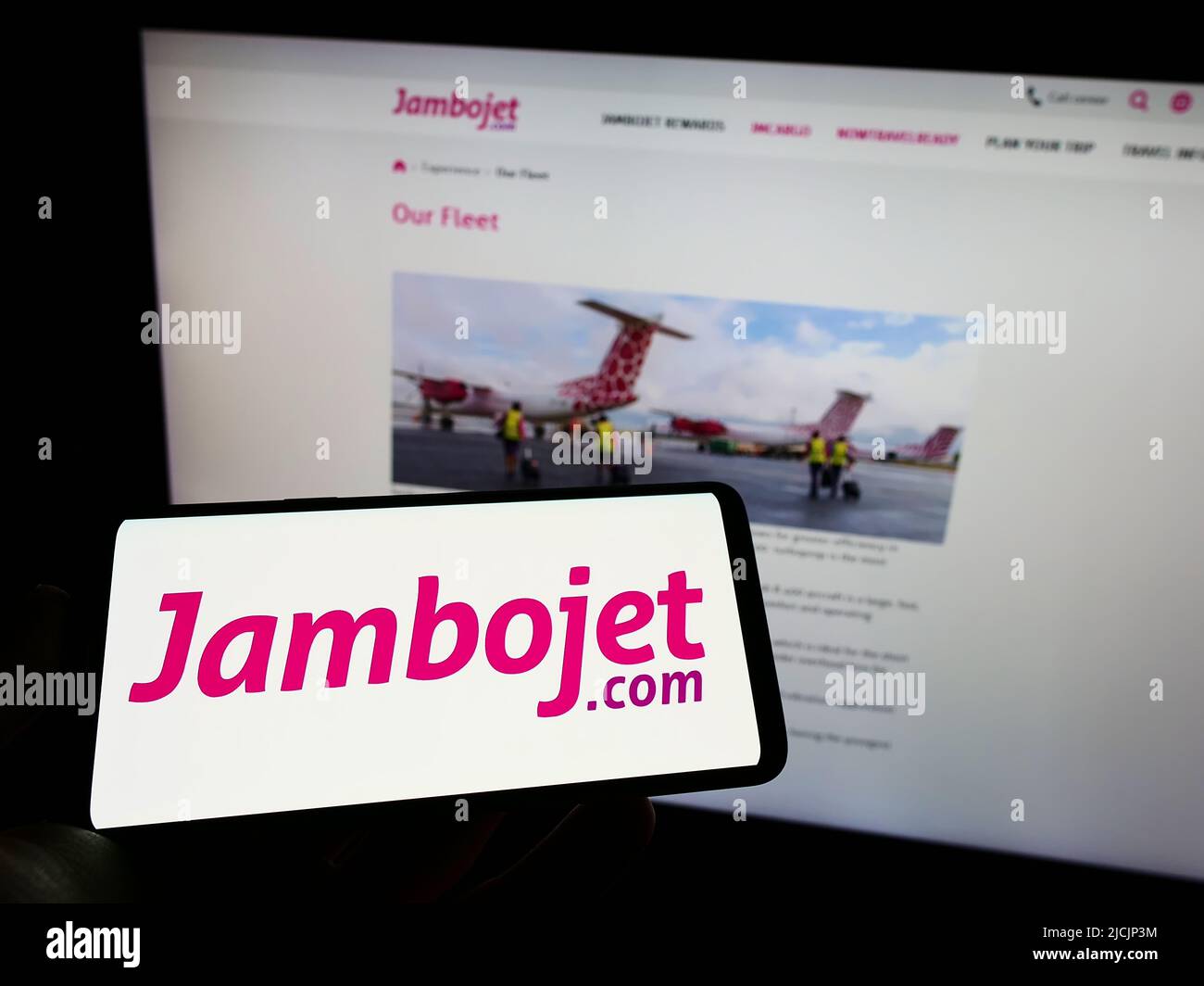 Person holding mobile phone with logo of Kenyan airline company ...