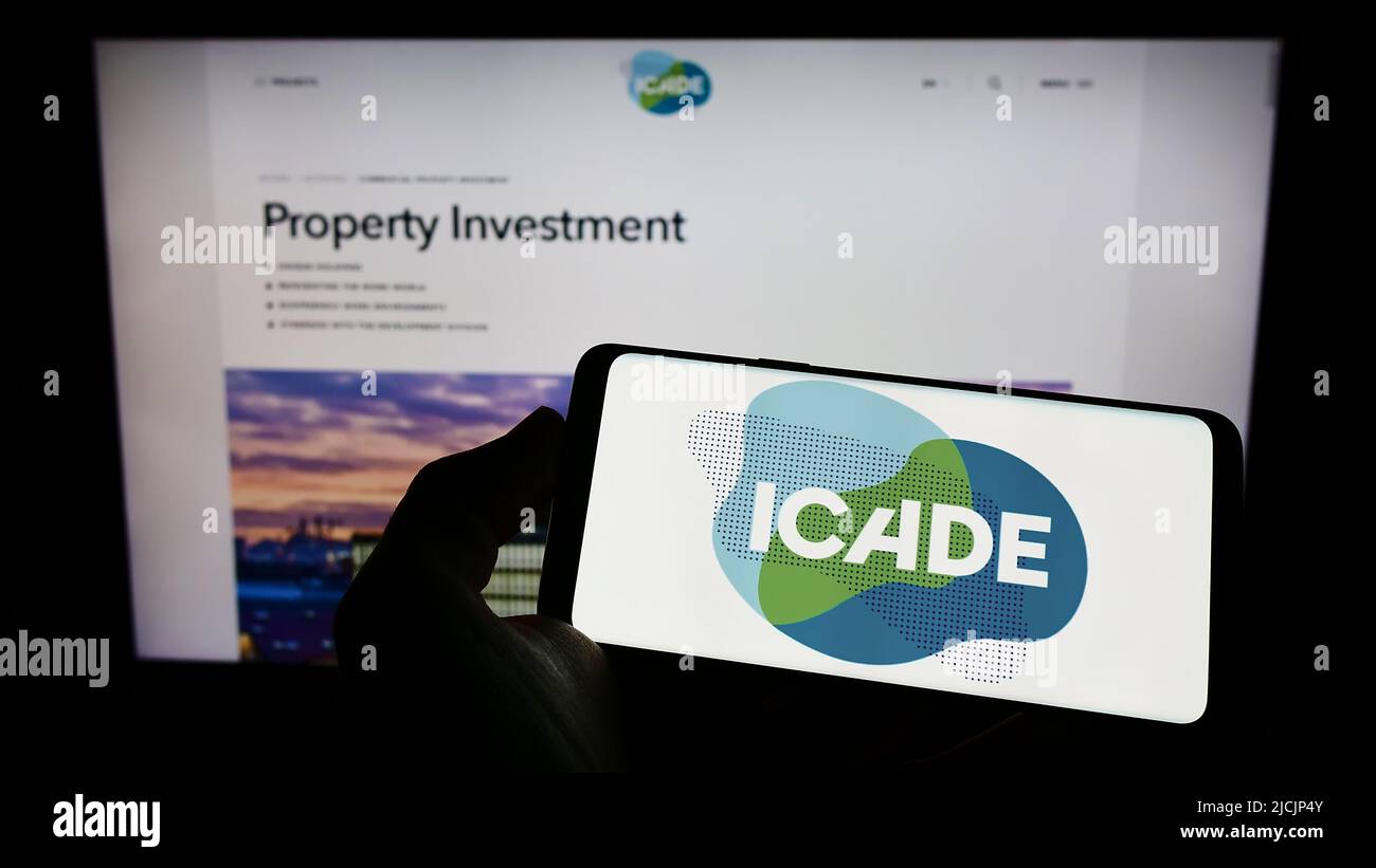 Person holding cellphone with logo of French real estate company Icade ...