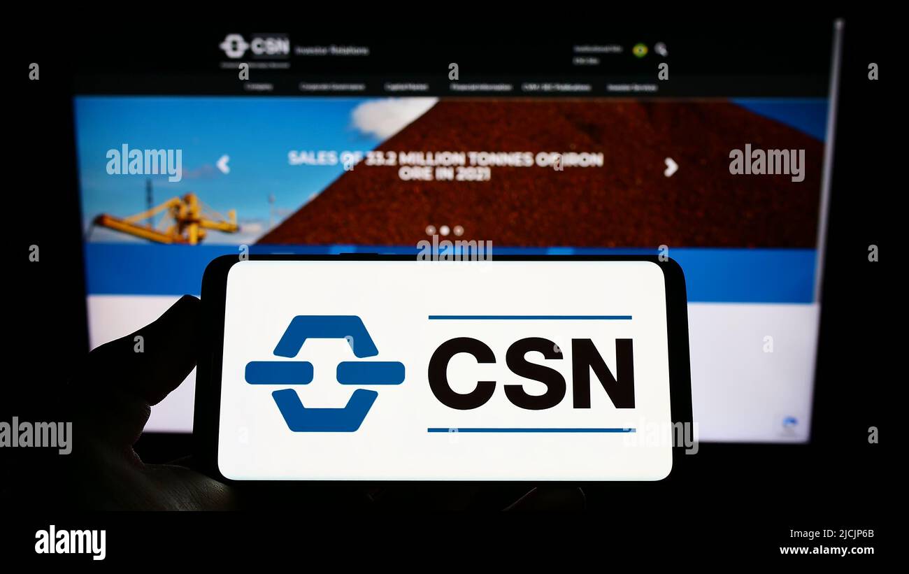 Person holding smartphone with logo of company Companhia Siderurgica ...