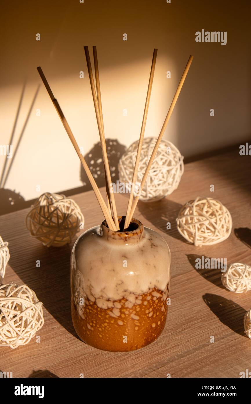 Cozy home decorations aroma reed diffuser in the living room. Home comfort concept. Bottle ...