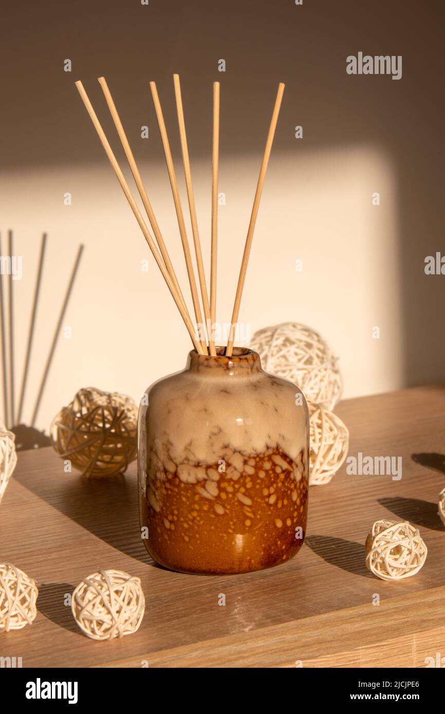 Cozy home decorations aroma reed diffuser in the living room. Home comfort concept. Bottle ...