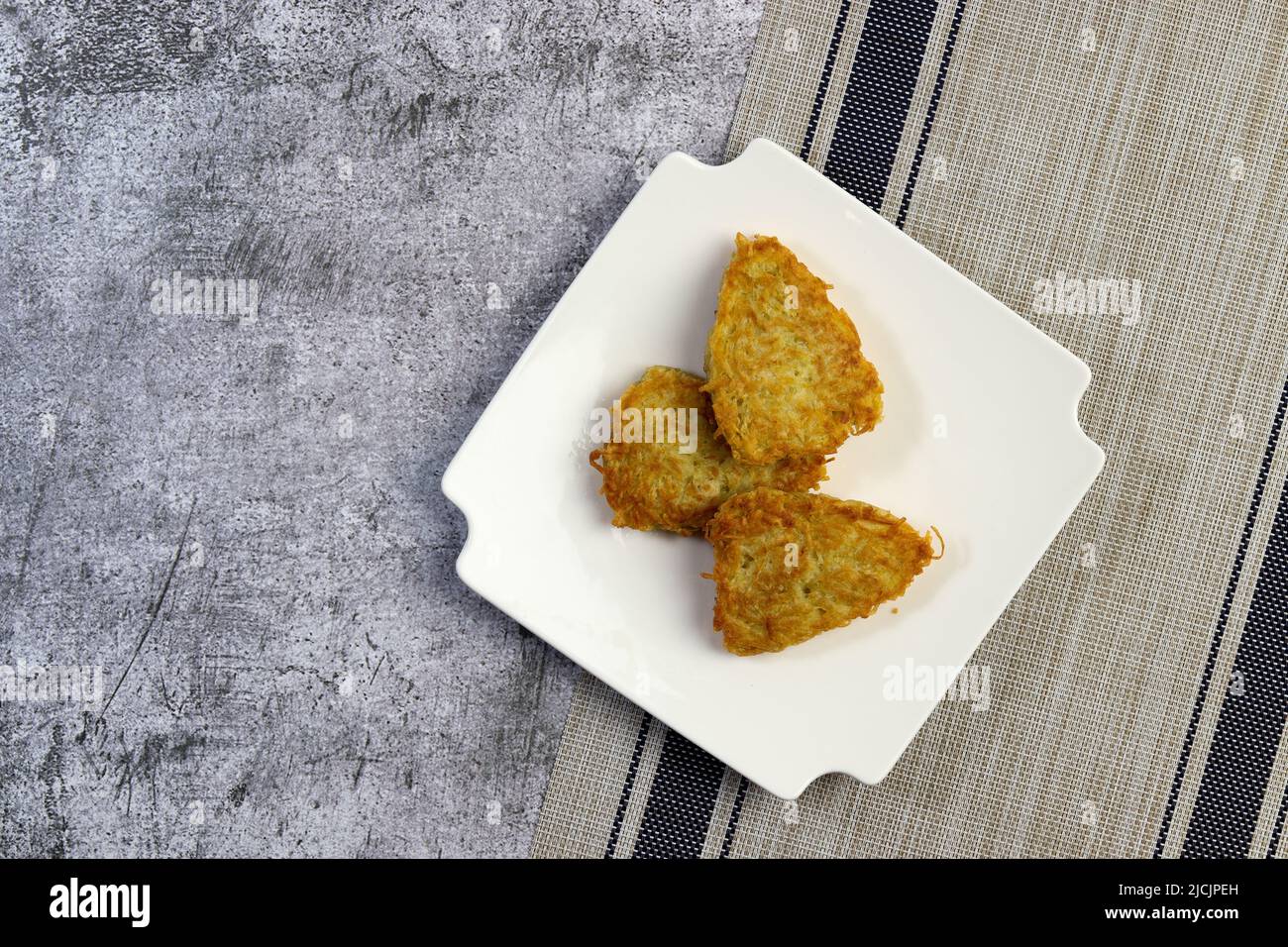 Traditional Hash brown potato fried pancakes on a white square plate on ...