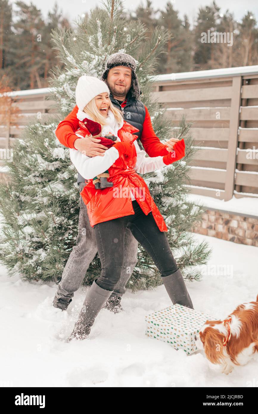 Happy couple walking in Park in winter and playing with snow, fun play ...