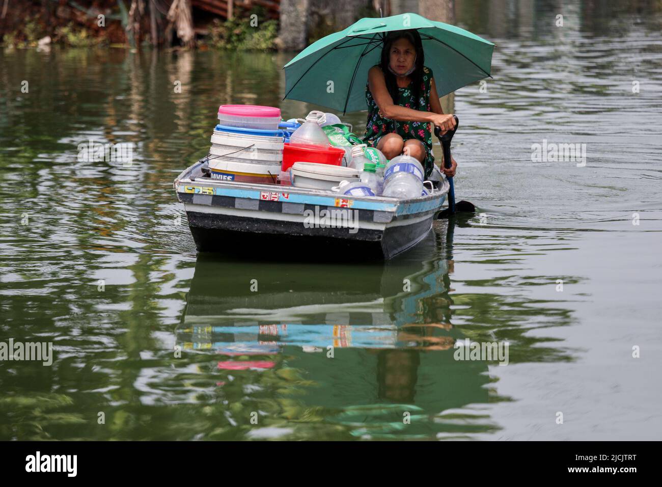 June 8, 2022, Manila, Philippines: A resident paddles on stagnant ...