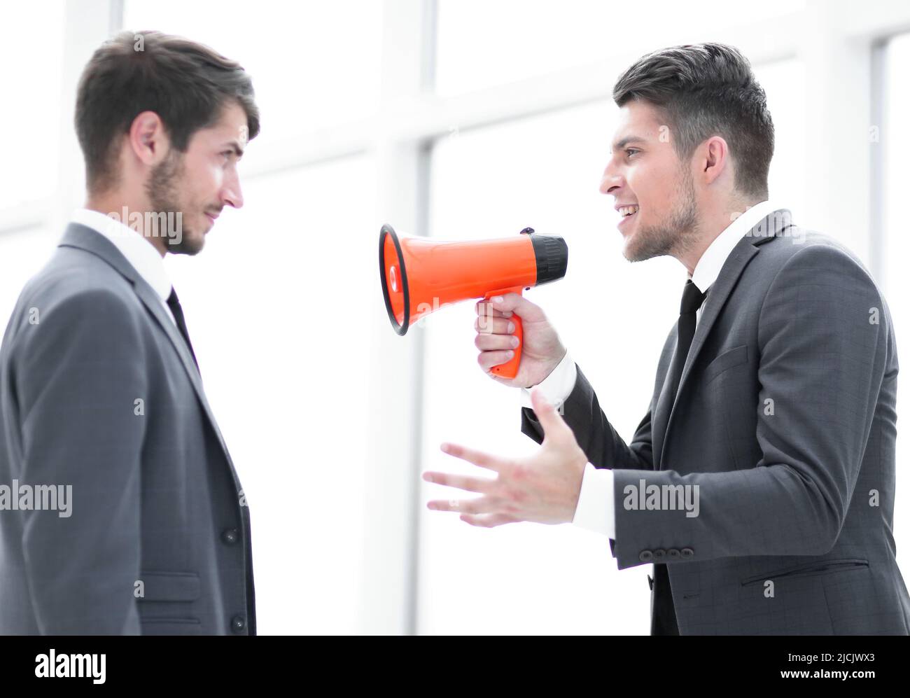 aggressive businessman with megaphone screaming on his coworker ...