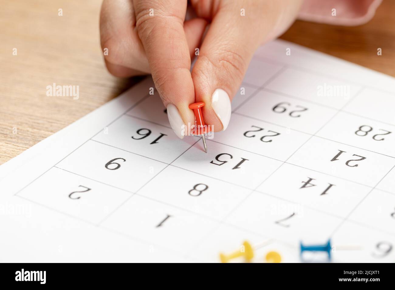 red Hand pin stuck on the day of the month in the calendar, business ...