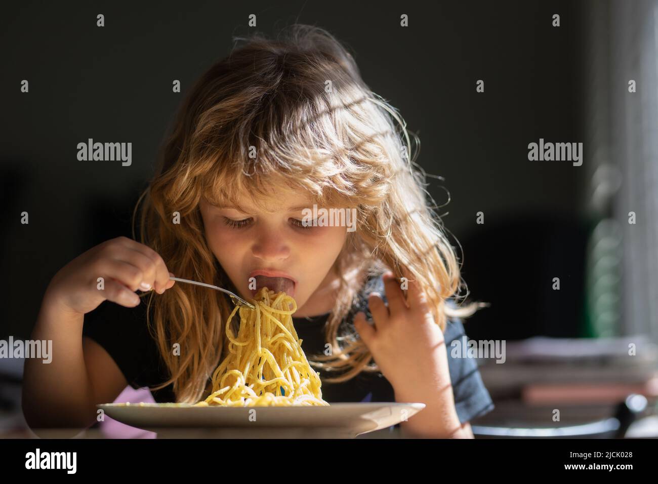 Cute child eats food itself with spoon. Cute little kid eating ...