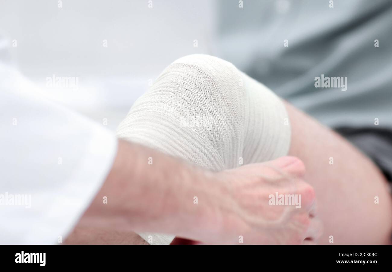 closeup. doctor bandaging a patient's leg Stock Photo - Alamy