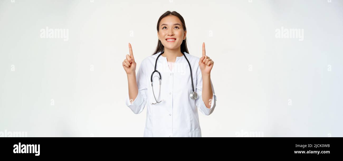 Happy smiling doctor, asian woman physician looking up with cheerful ...