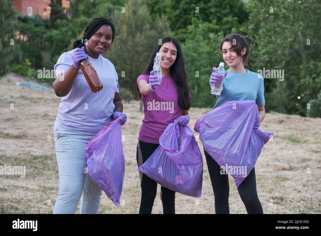 Group of multiracial active women showing proudly trash bags from ...