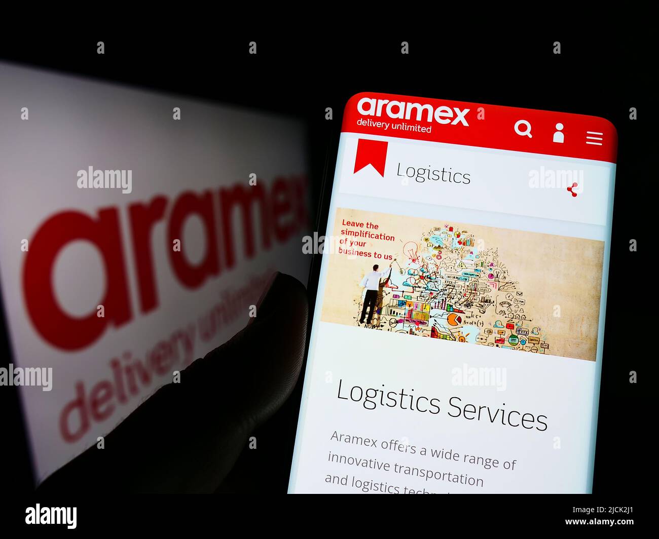 Person holding cellphone with webpage of Emirati logistics company ...
